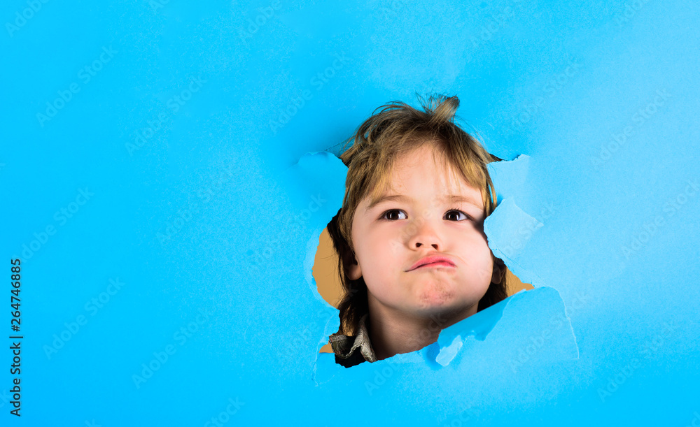 Through paperwall. Angry boy looking through paper. Kid looking through ...