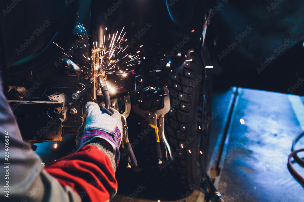 professional repairman worker in automotive industry welding metal body ...