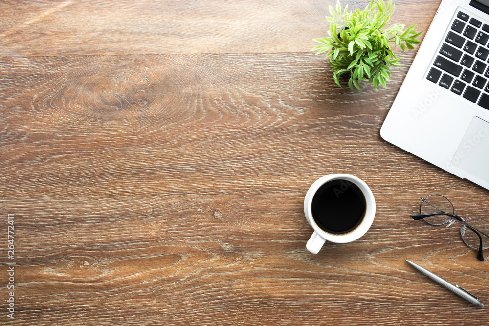 Wood office desk table with laptop, cup of coffee and supplies with ...