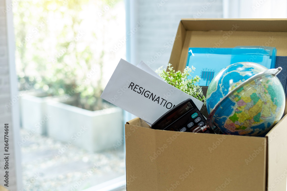 Resignation letter and cardboard box on the desk. Concept of ...