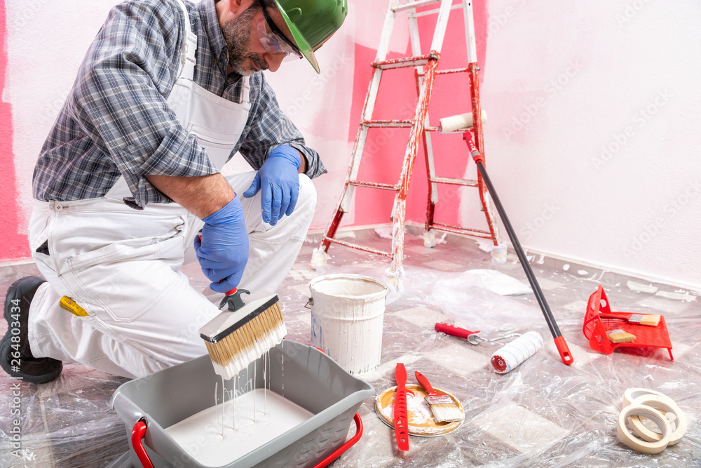Caucasian house painter worker in white overalls, with helmet and ...