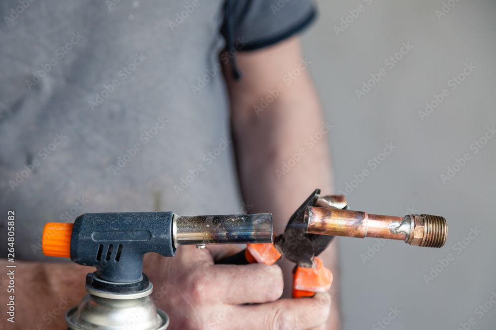 Closeup professional master plumber holding flux paste for soldering ...