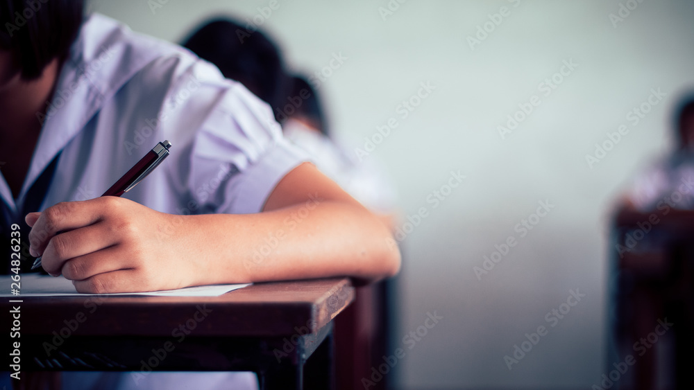 School Students hands taking exams and writing examination with holding ...