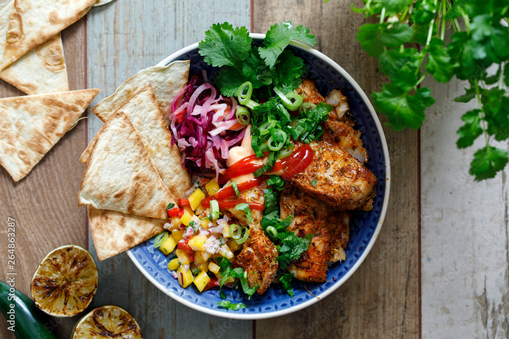 Mexican style bowl with fish, mango salsa and tortilla Stock Photo ...