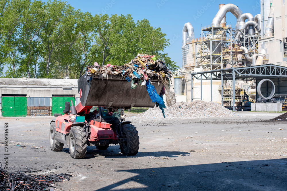 Front loader transporting municipal waste in the waste treatment plant ...