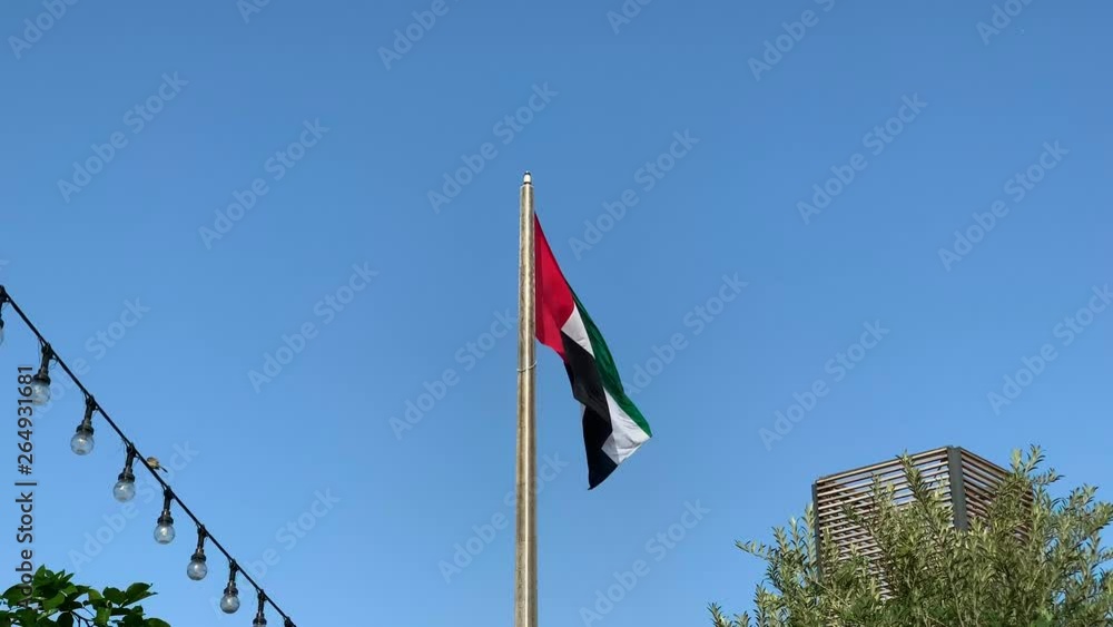 UAE flag waving in Dubai city , national symbol of UAE. blue sky, uae ...