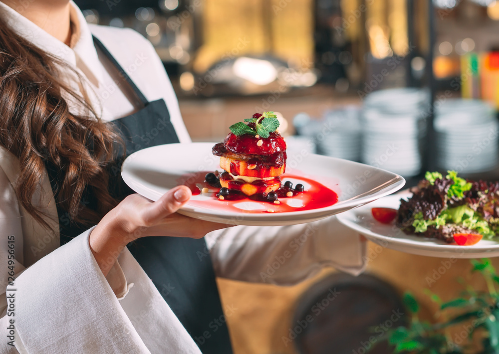 Waiter serving in motion on duty in restaurant. The waiter carries ...