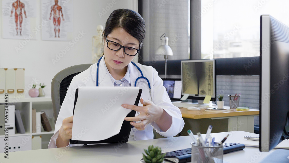 smart medical intern doctor woman reading patient file on clipboard in ...