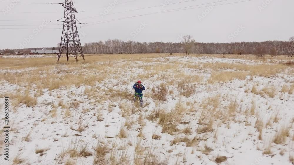 Stockvideon Electrician man going on the snow field at electrical ...