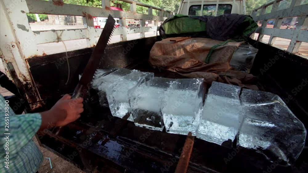 Process of ice cutting. Unidentified man is cutting ice into blocks for ...