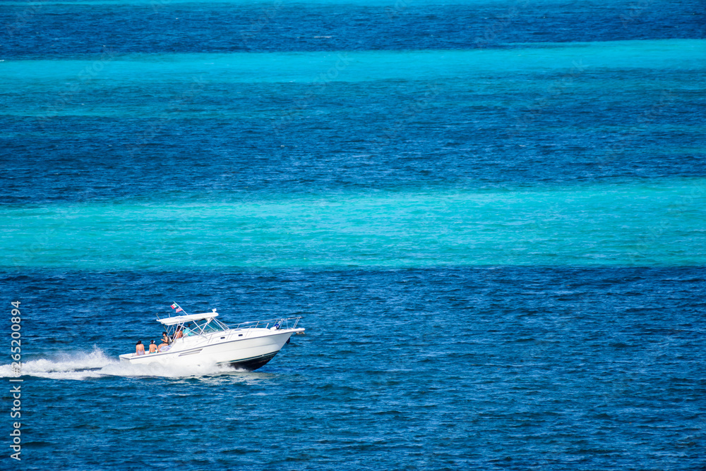 Bote deportivo navegando por el mar caribe con personas disfrutando de ... Bote deportivo navegando por el mar caribe con personas disfrutando de ...