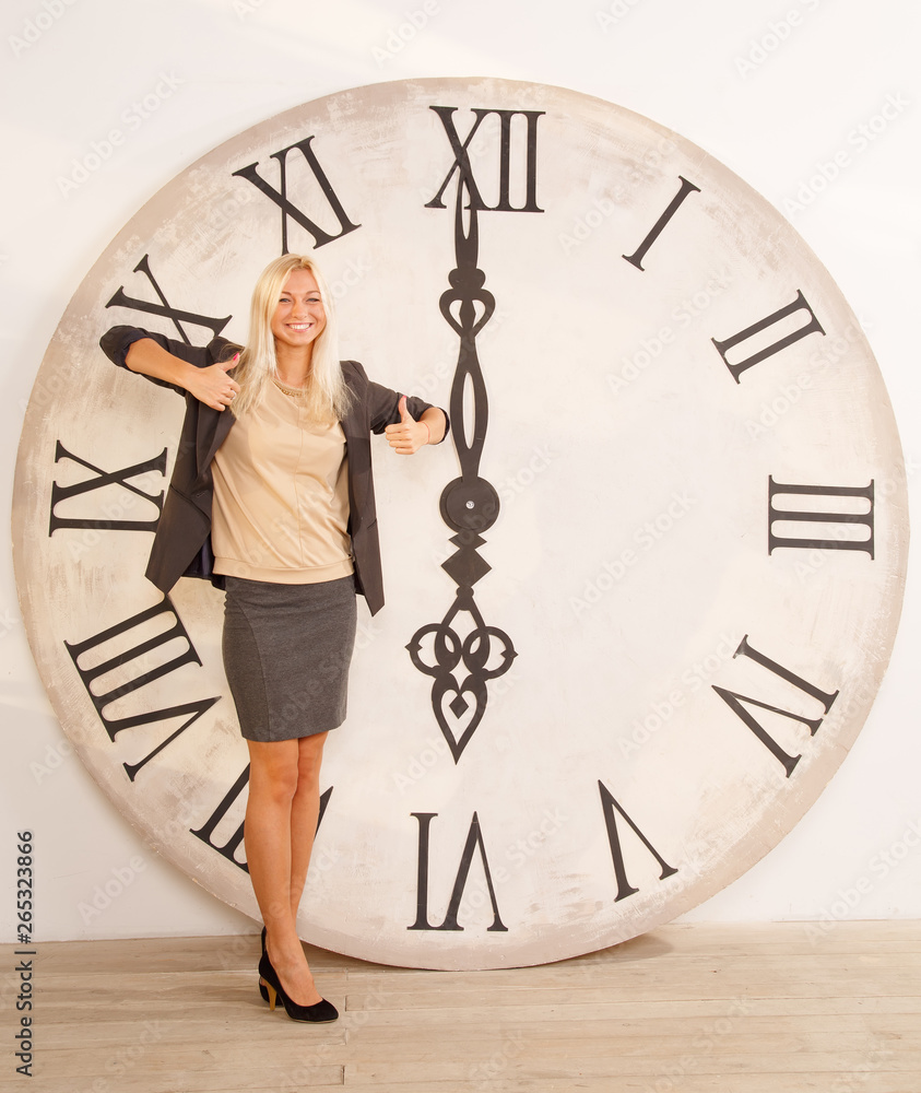 Woman standing near the clock. Arrows show the big clock time. The ...
