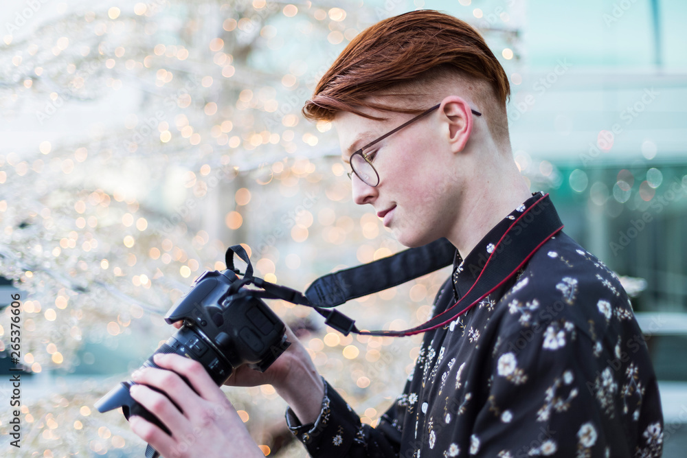 Foto de Teenage boy looking at the digital photographs on the screen of ...