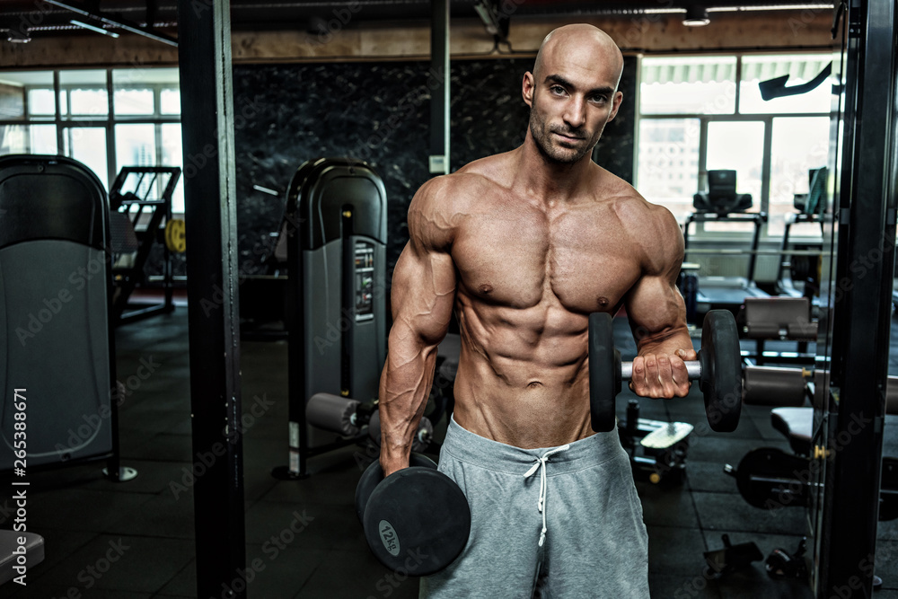 Young handsome sportsman bodybuilder weightlifter with an ideal body ...