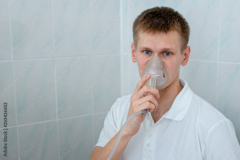 Young man wearing an inhalation mask. Use nebulizer and inhaler for the ...