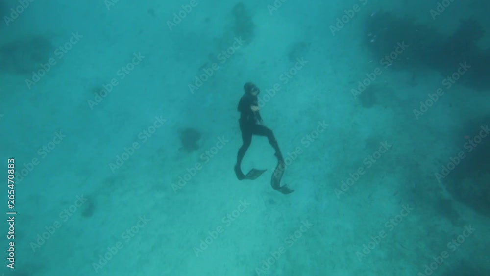 A hand held POV shot of a person diving underwater as a form of ...