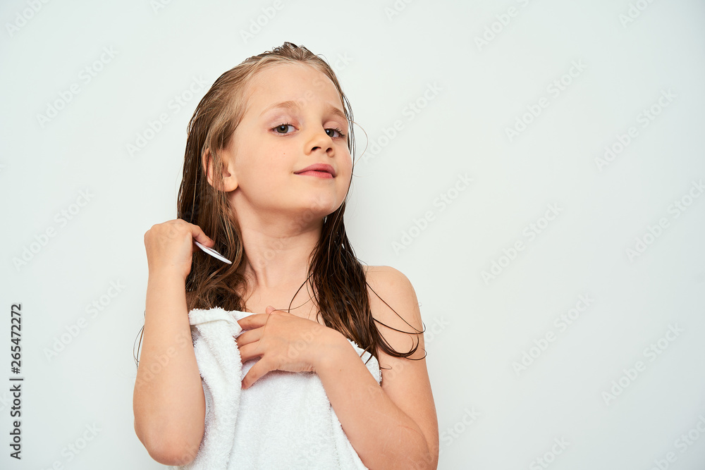 Smiling little preschool girl with wet hair photographed against white ...
