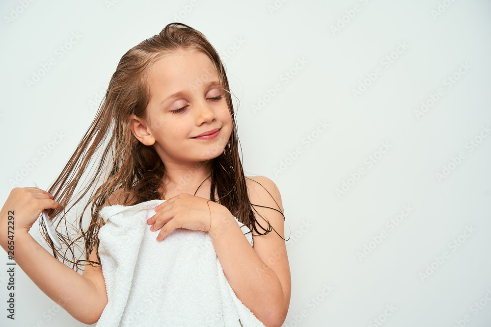 Smiling little preschool girl with wet hair photographed against white ...