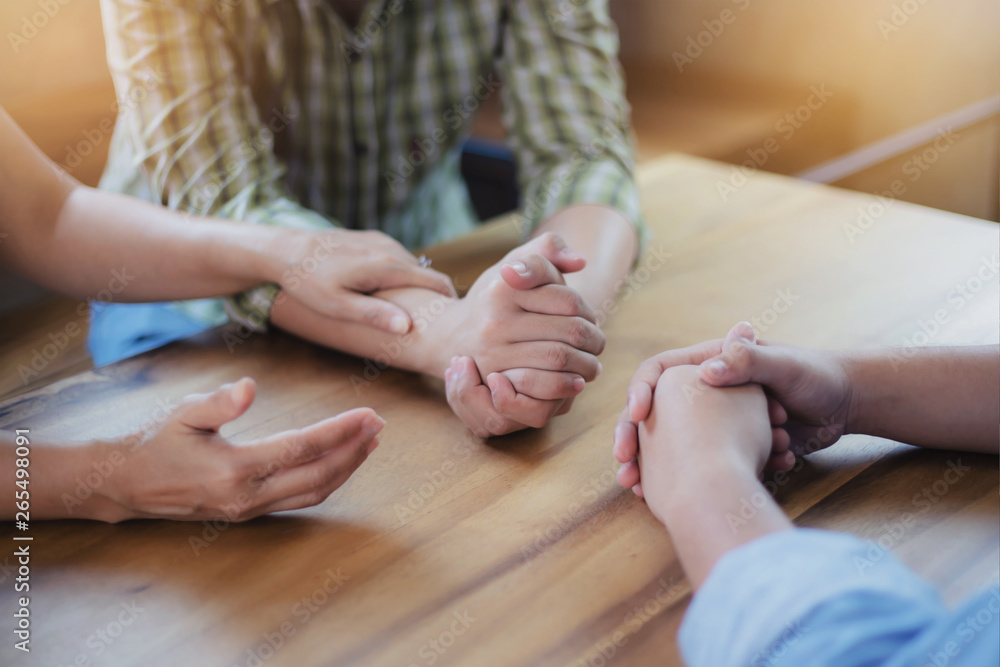 Two Christian people are praying for young man friends on wood table at ...