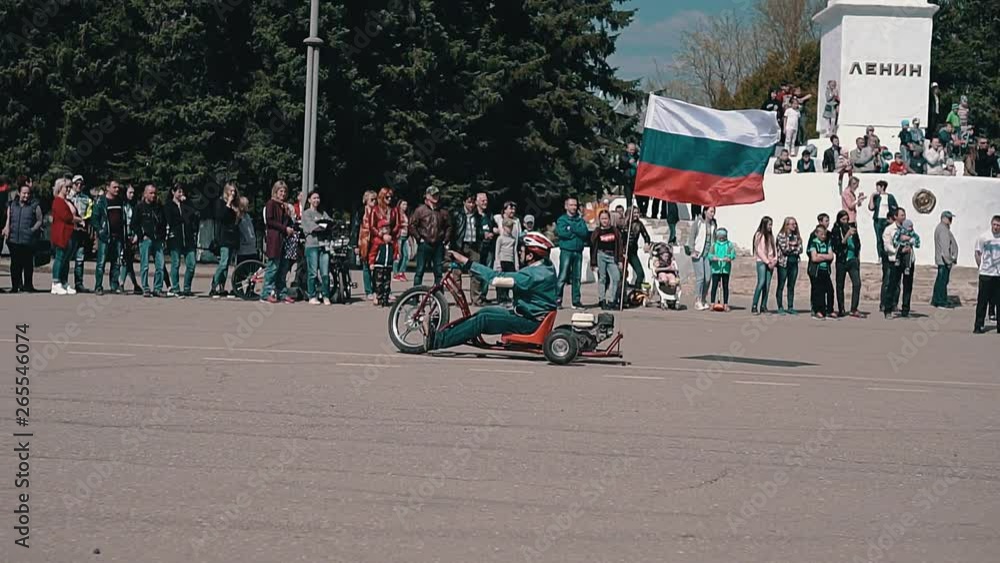 Cool biker on a tricycle rides along the crowd of spectators at the ...