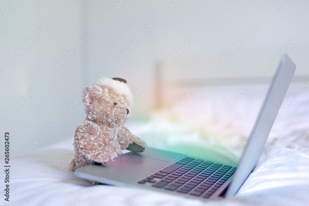 Alone Teddy bear sitting watching movie on laptop computer in bedroom ...