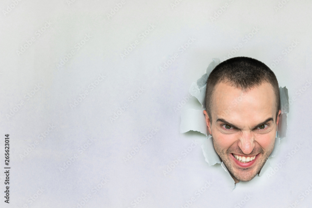 Evil man making hole in paper, looking at the camera, gloating, facial ...