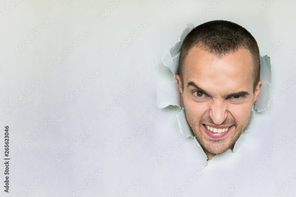 Foto de Evil guy making hole in paper, looking at the camera, gloating ...