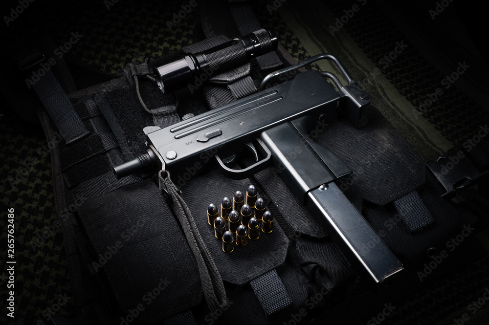 Submachine gun and 9mm round laid on a tactical vest Stock Photo ...