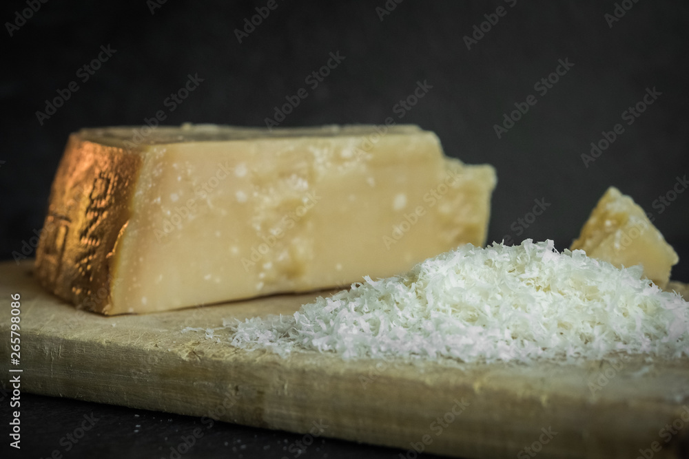 Grated parmesan cheese on black background, italian food. Stock Photo ...