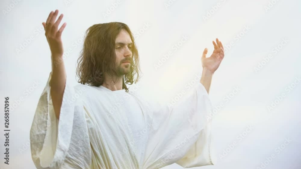 Jesus raising hands illuminated with light, resurrection and ascension ...