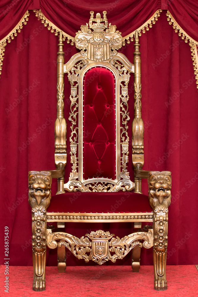 Red royal chair on a background of red curtains. Place for the king ...