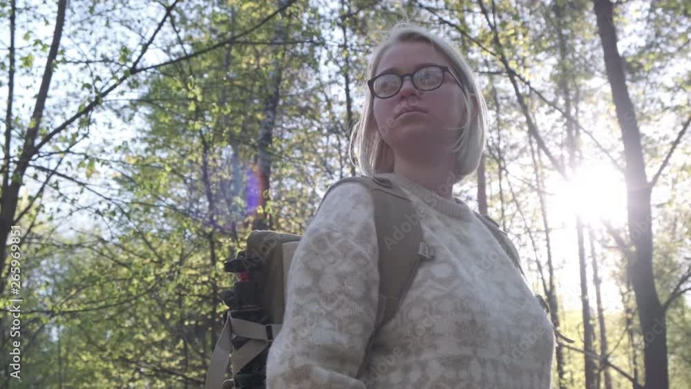 Vidéo Stock Young woman walks in sunny morning forest park enjoying ...