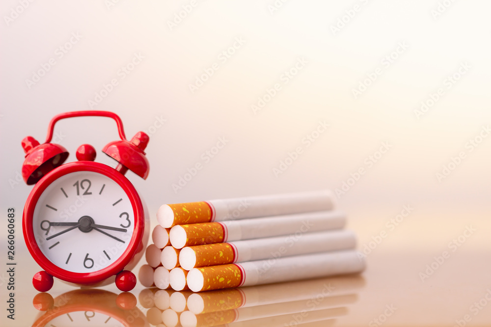 Cigarettes stack and red alarm clock. World no tobacco day. Cigarette ...