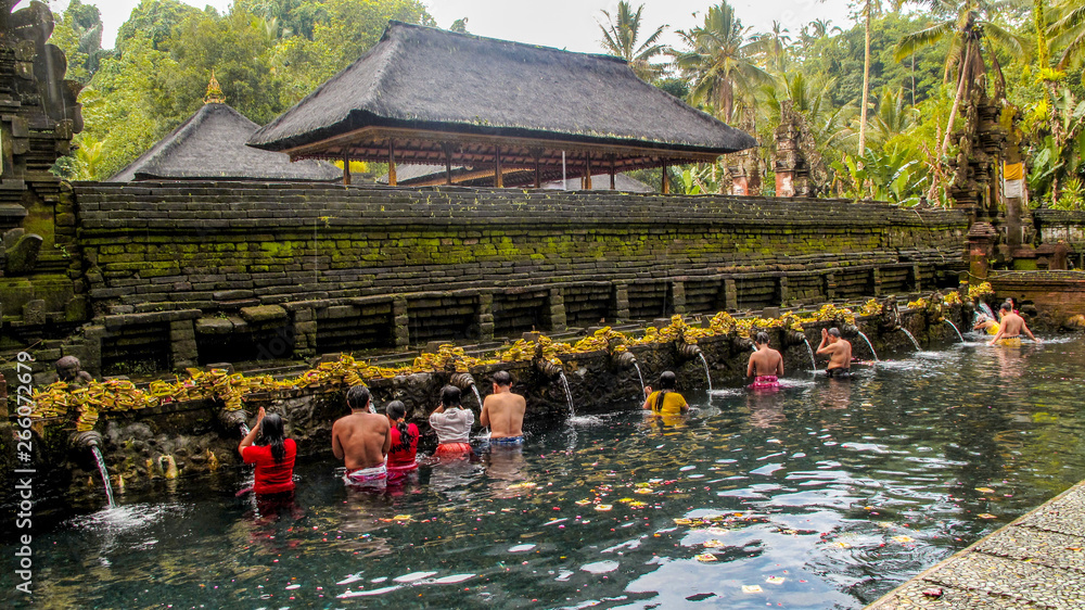 People are doing the ritual purifying bath at Tirta Empul temple, a ...