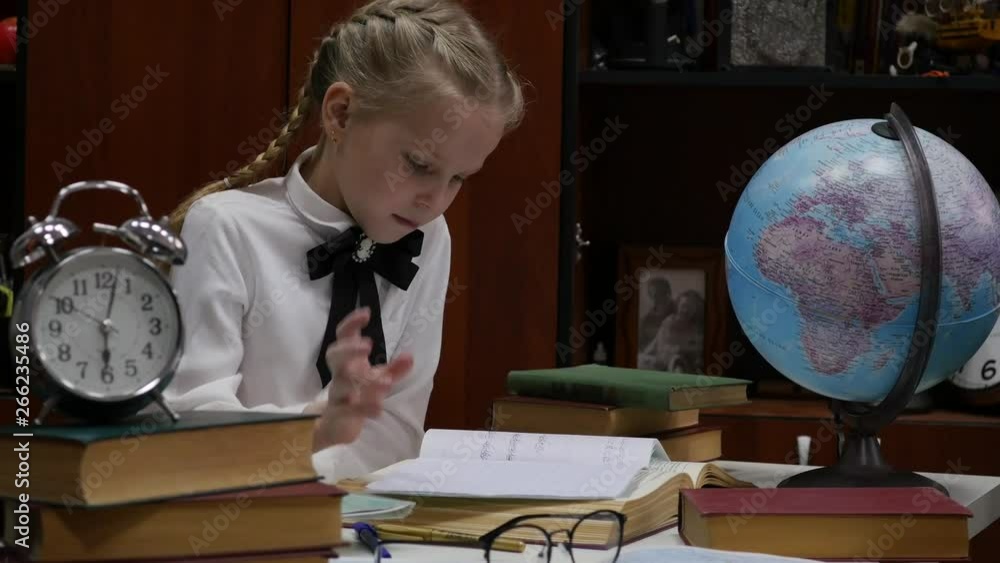 Schoolgirl doing homework, little blonde girl studing at home at the ...