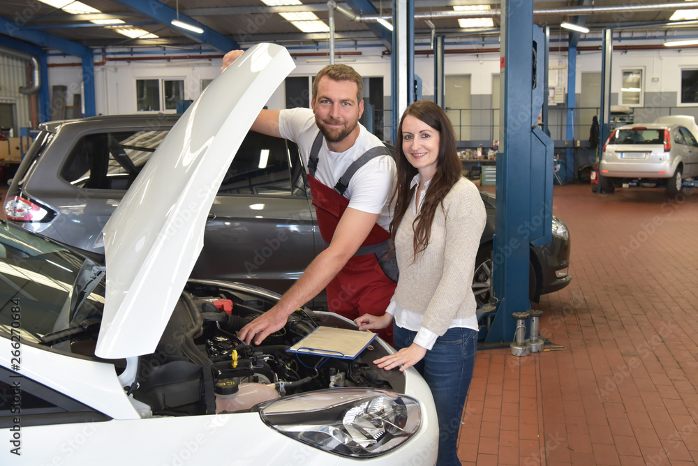Automechaniker und Kundin in der Werkstatt - Beratung und Kundendienst ...
