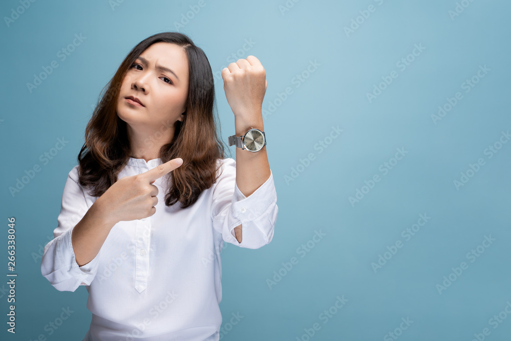 Angry woman pointing at her watch Stock Photo | Adobe Stock