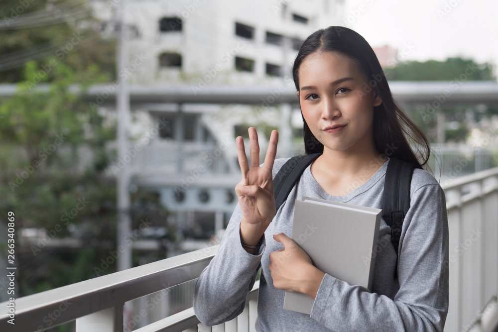 portrait of happy smiling asian woman college student pointing up 3 ...