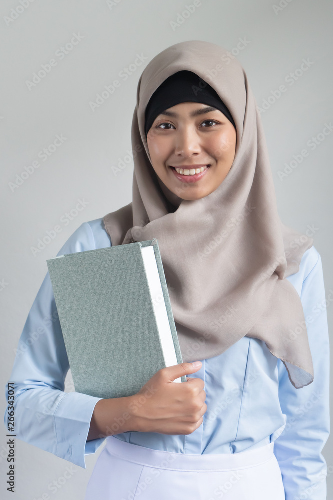 young adult asian muslim woman with the Quran, islamic holy book ...