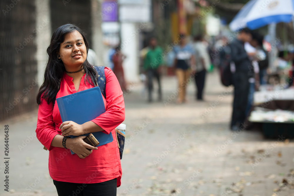 College student standing in a busy street in a city and looking at ...