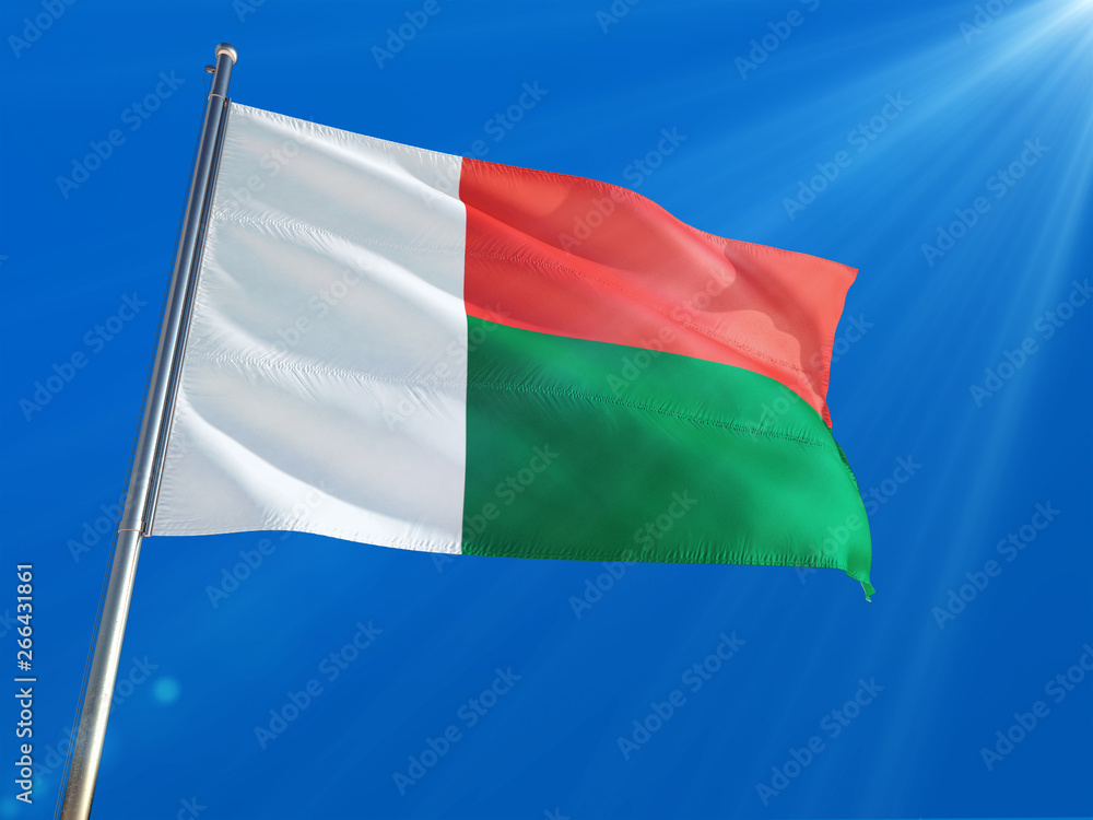Madagascar National Flag Waving on pole against deep blue sky ...