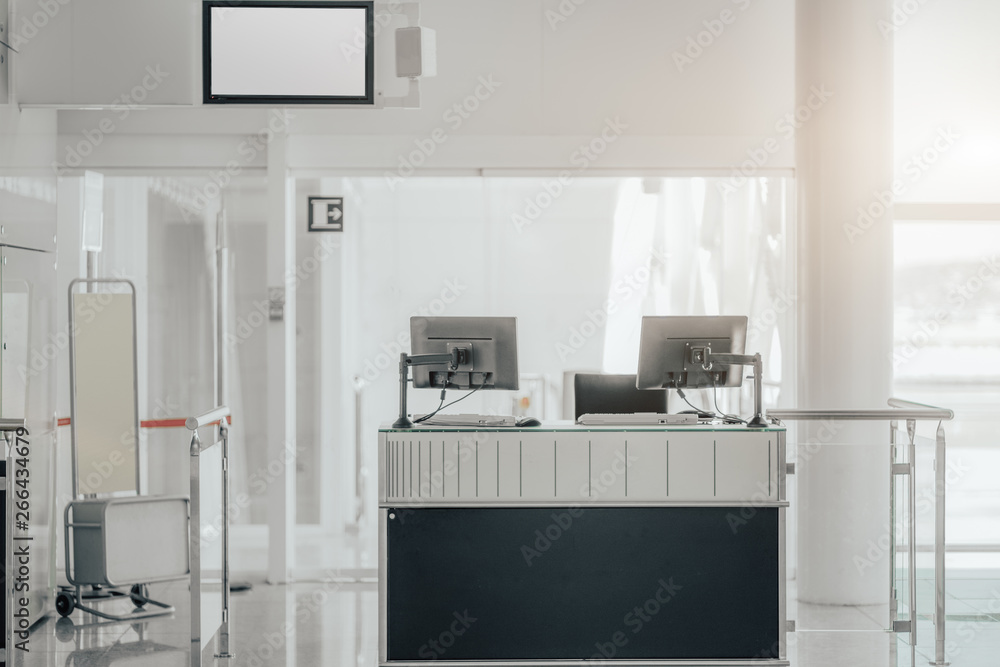 An empty gate of a modern airport terminal with computer monitors on ...
