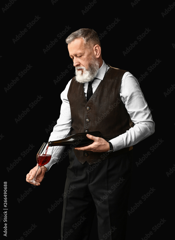 Portrait of elegant mature sommelier on dark background Stock Photo ...