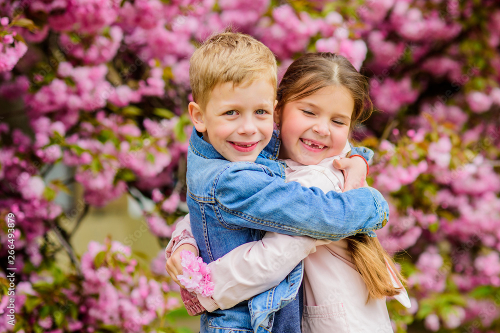 Love is in the air. Kids in love pink cherry blossom. Romantic babies ...
