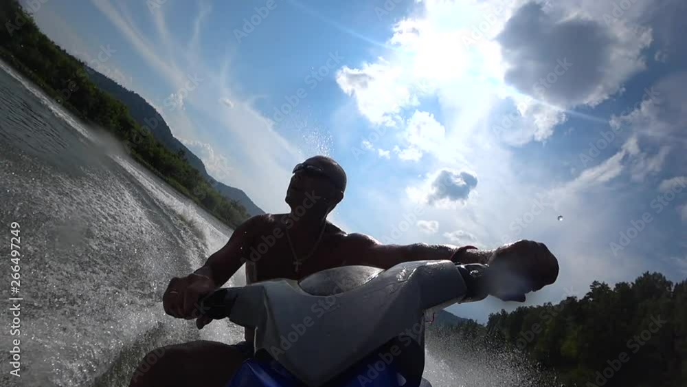 muscular guy rides on the river on a jet ski. riding a jet ski on a ...