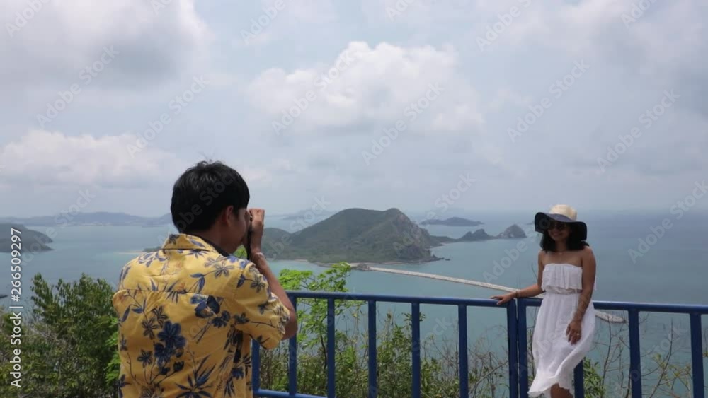 Beautiful young asian tourist woman posing in front of male friend ...