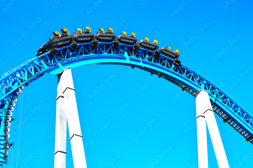 Blue spooky scary roller coaster fast riding with loop and yellow seats ...