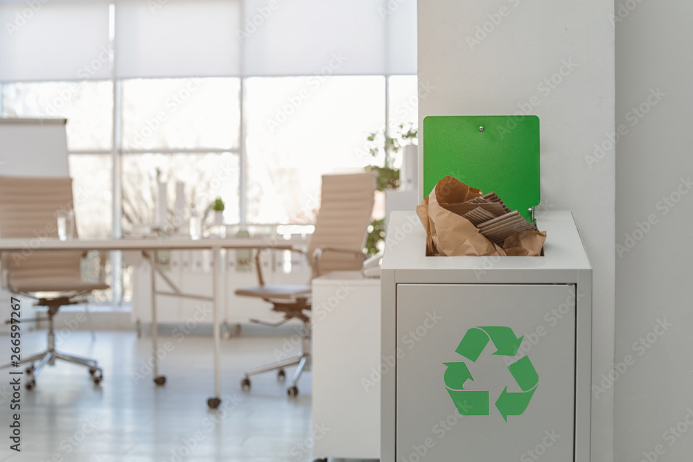 Open full trash bin in modern office, space for text. Waste recycling ...