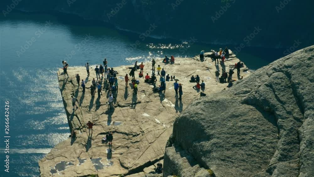 Tourist walking dangerously close to the edge of Preikestolen or Pulpit ...