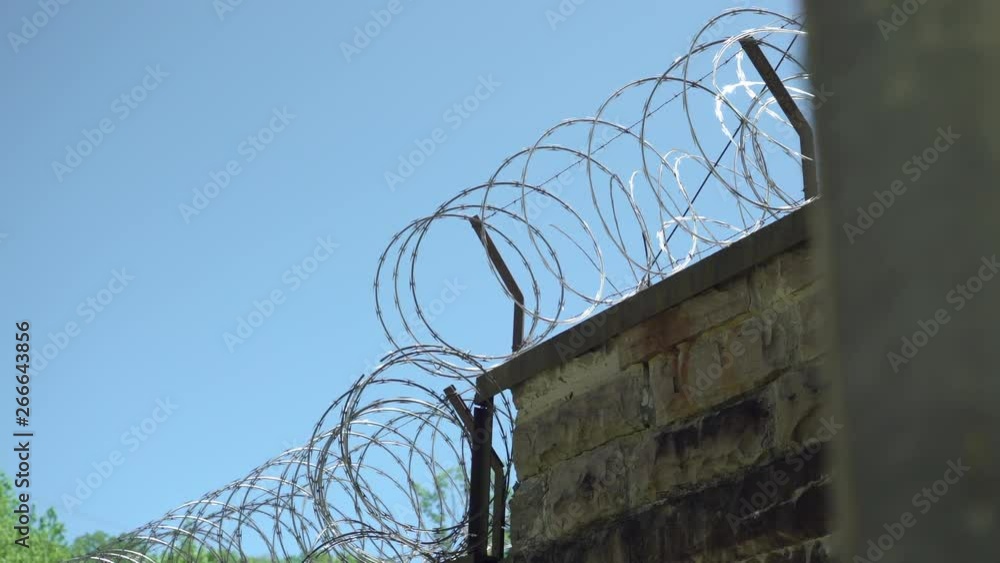 Prison or Jail Razor wire on Stone Wall and Fence Stock Video | Adobe Stock